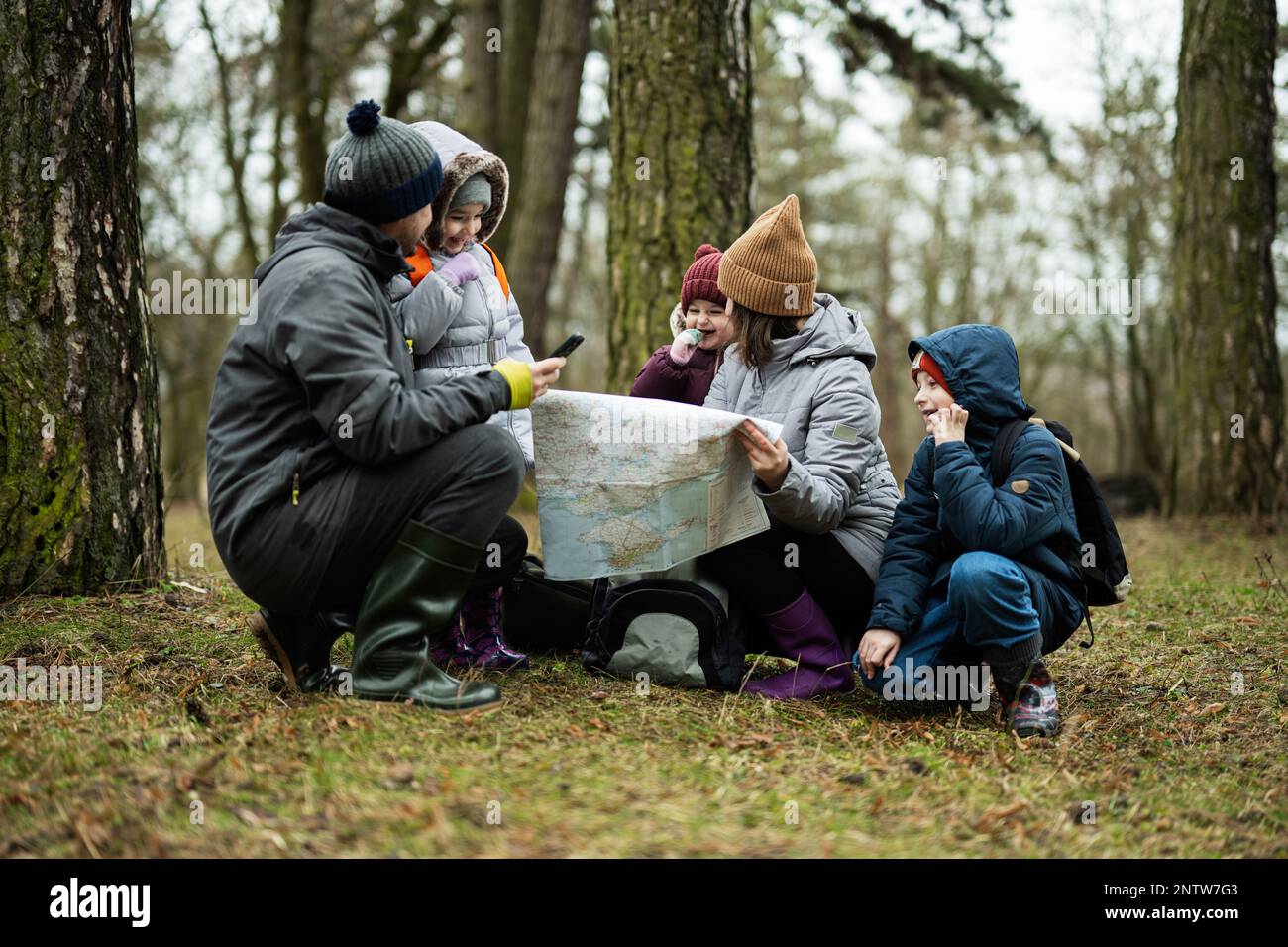 Family and kids with map in the forest Stock Photo - Alamy