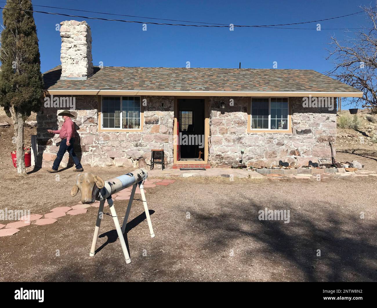 Rancher Hank Brackenbury walks in front of an old stone house at the 7J ...