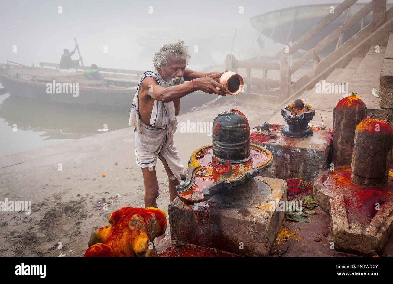 Pilgrim making a ritual offering and praying, ghats of Ganges river ...
