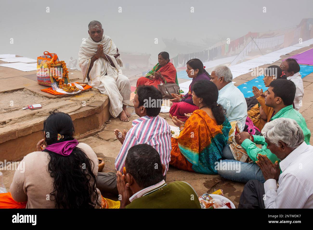 Pilgrims making a ritual offering and praying, ghats of Ganges river ...