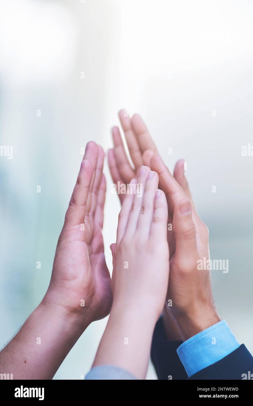 Success. Shot of a group of people giving each other a high five Stock ...