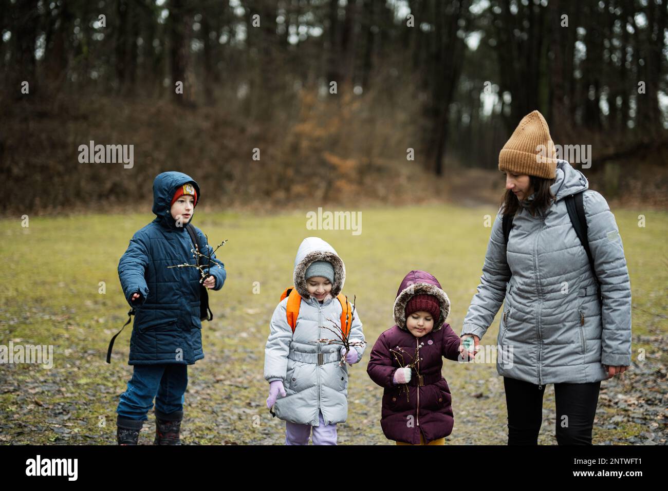 Mother with kids holding willow twigs while traveling in forest Stock ...