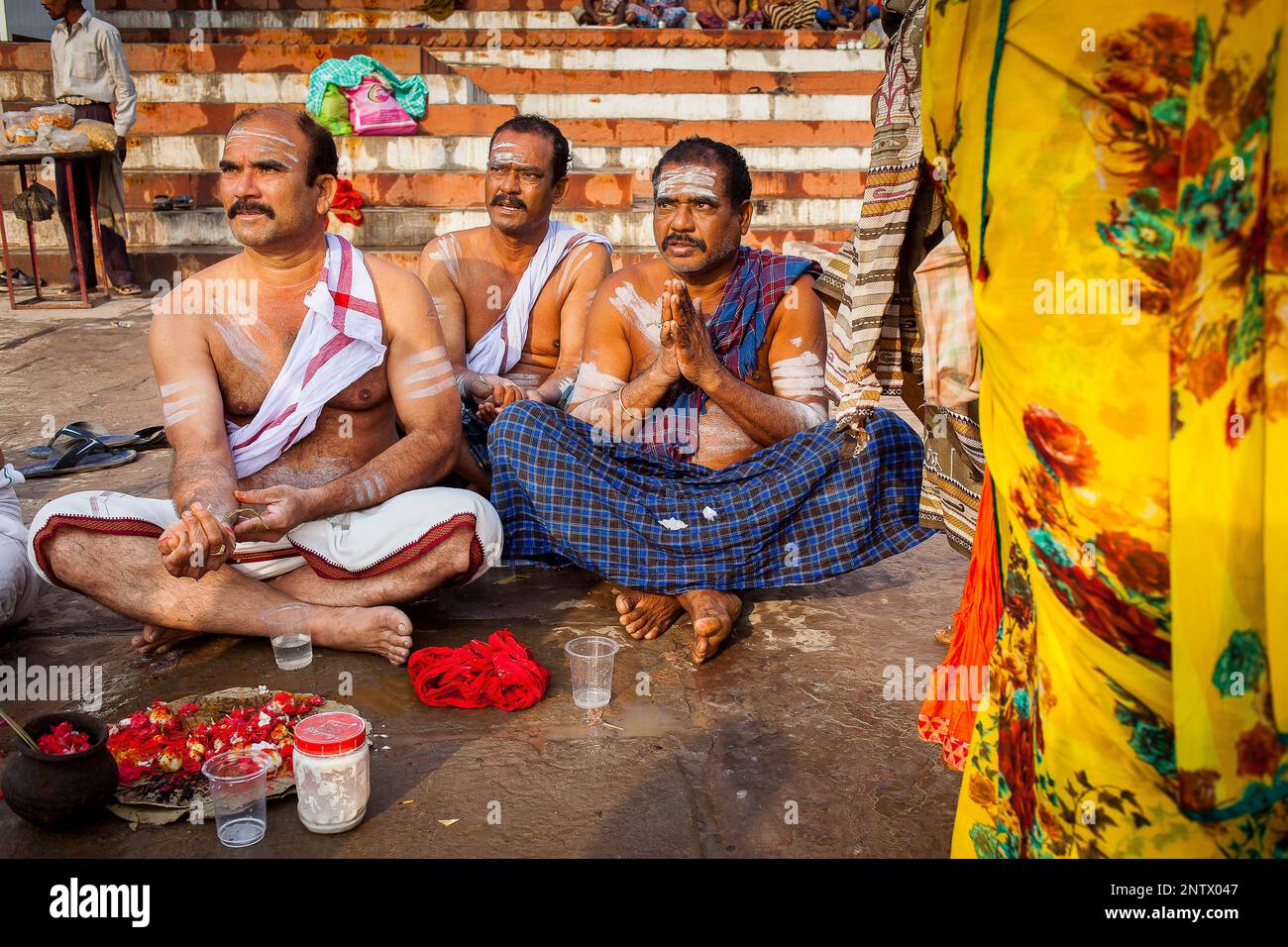 Pilgrims making a ritual offering, and praying, ghats in Ganges river ...