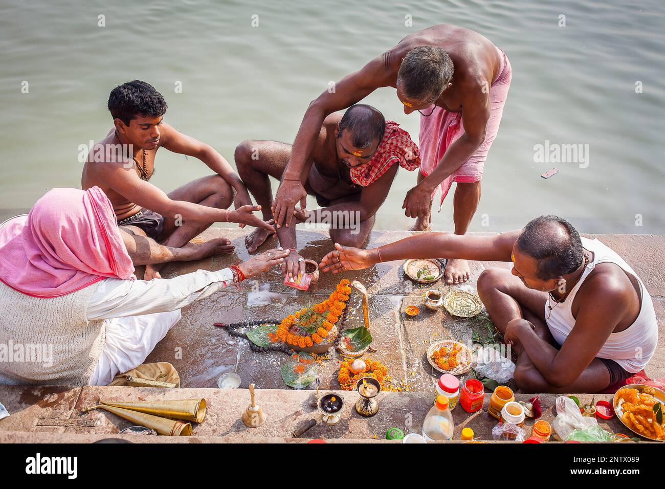 Pilgrims making a ritual offering and praying, ghats of Ganges river ...