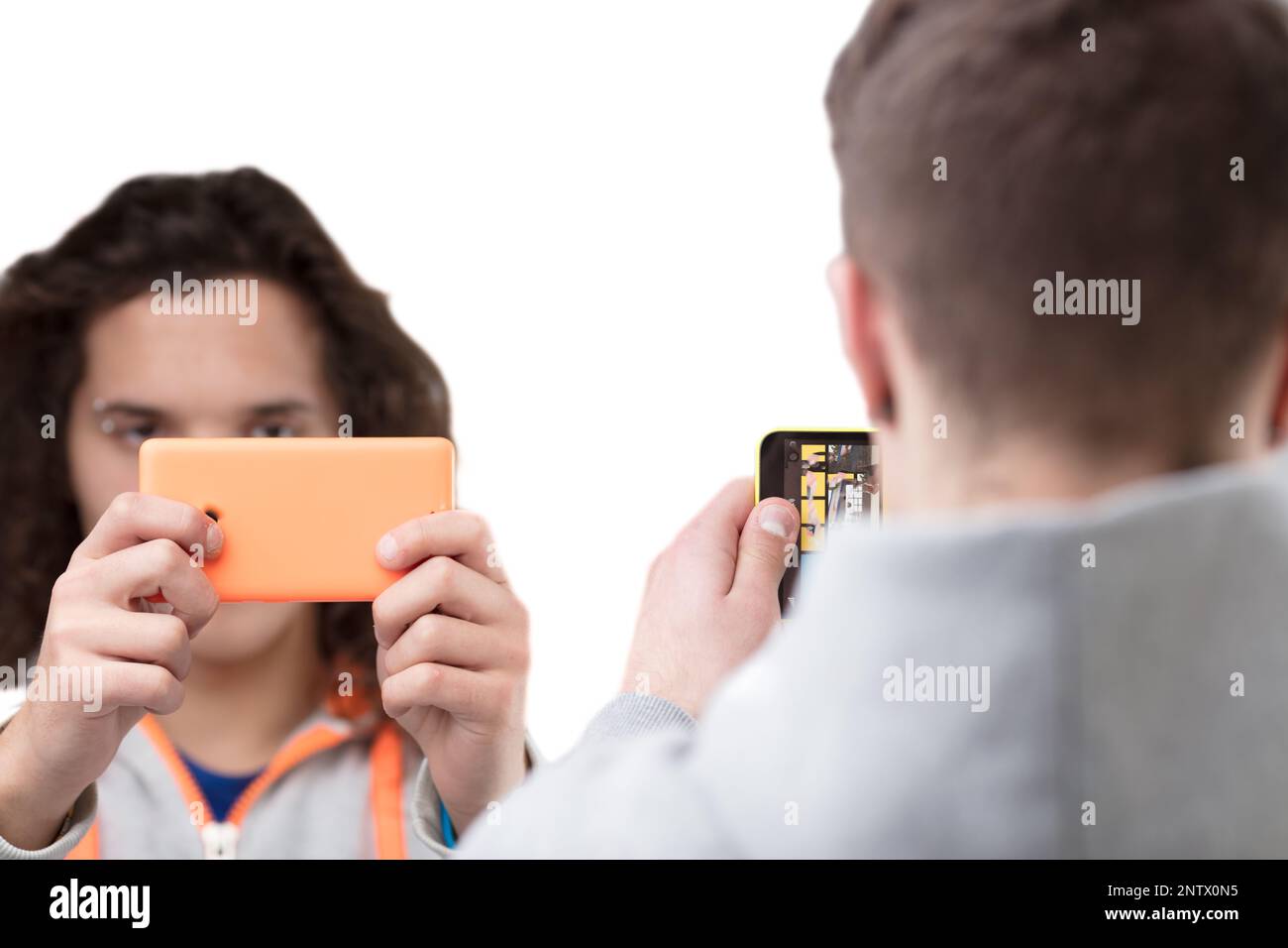Two boys stand in front of each other. Each of them is focused on ...