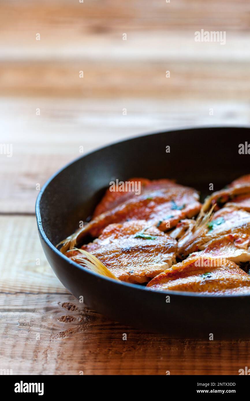 red mullet fish cooked on a pan, side view, selective focus, vertical ...