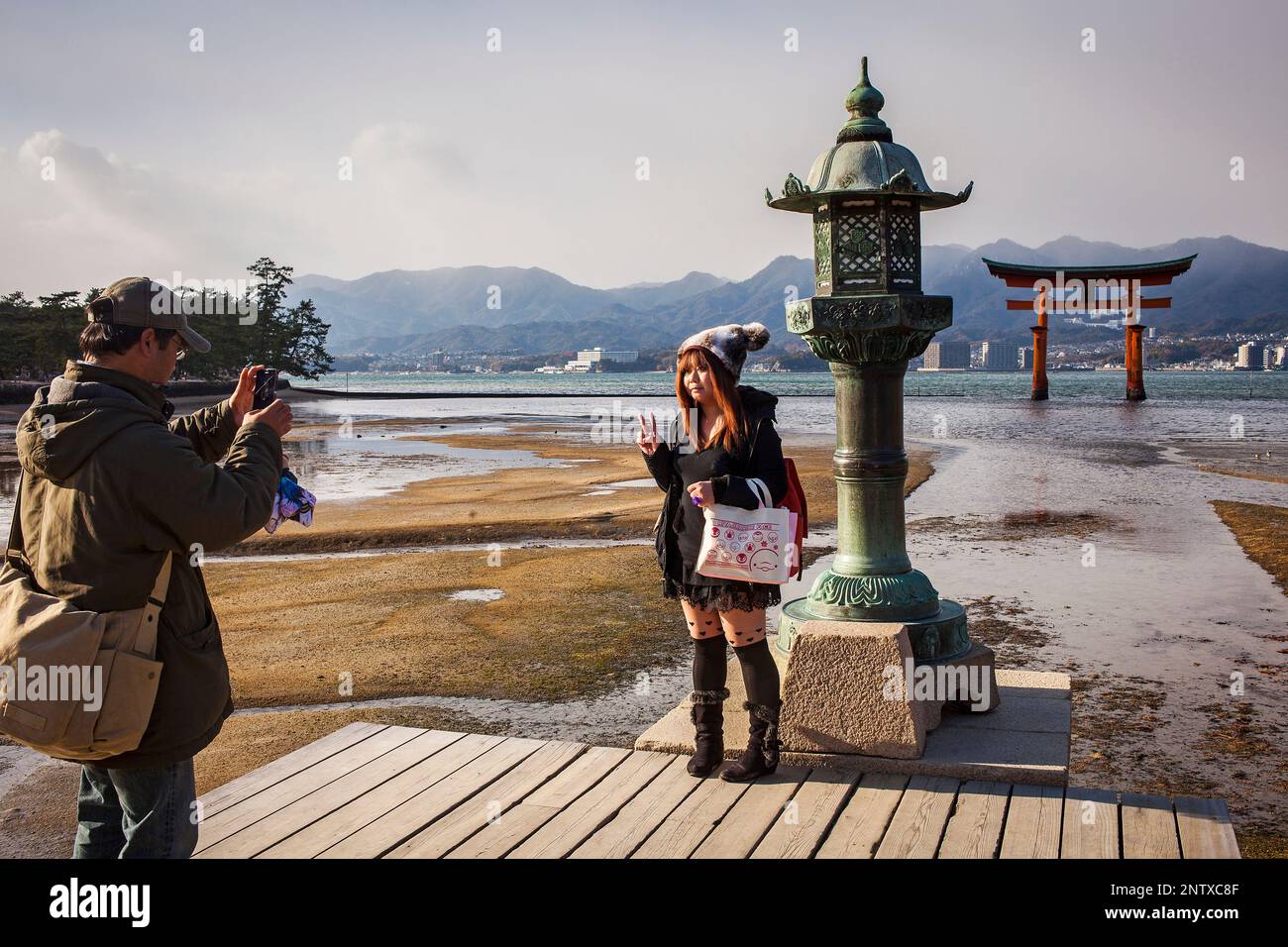 Visitors, Itsukushima Shinto Shrine complex, in background O torii Gate ...