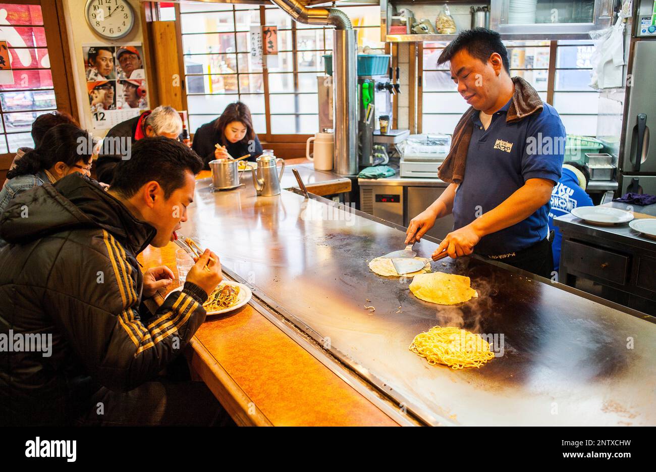 Chef Cooking Okonomiyaki, in a restaurant of Okonomi-mura, Hiroshima ...