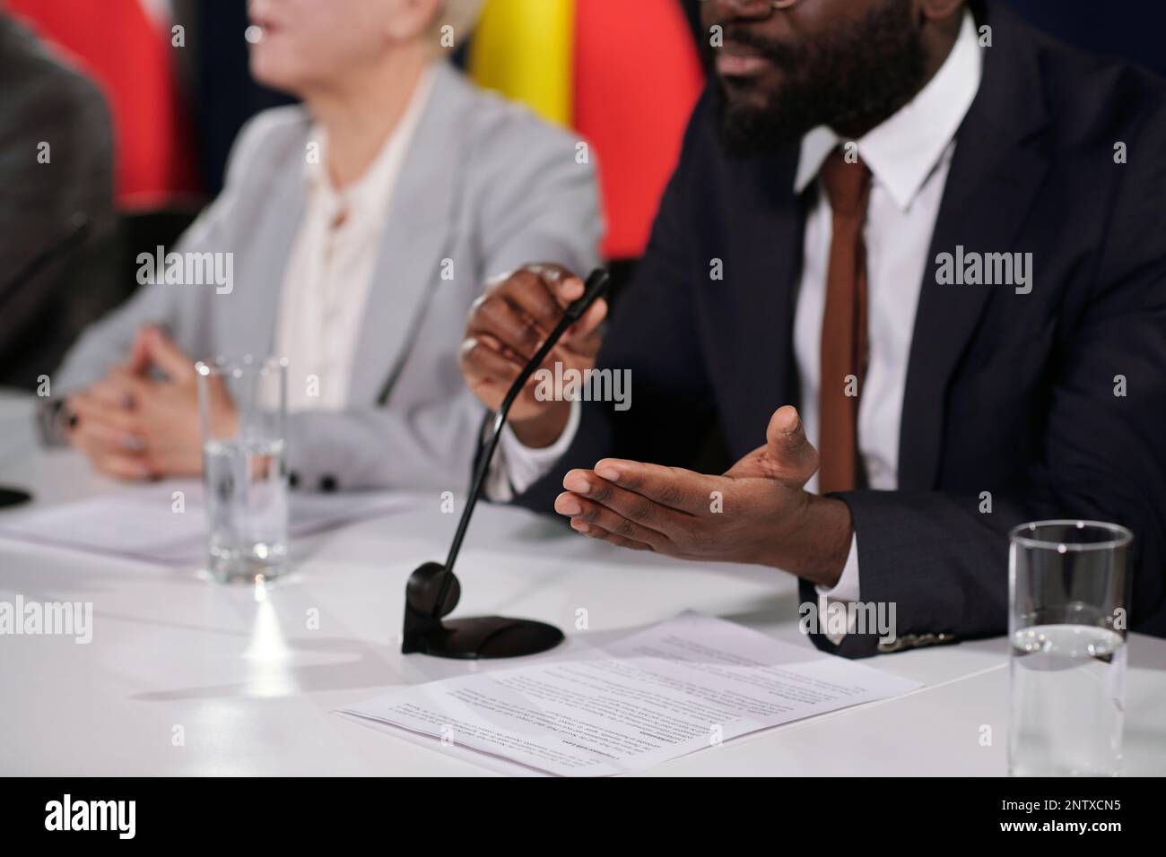 Close-up of young African American delegate sitting in front of ...