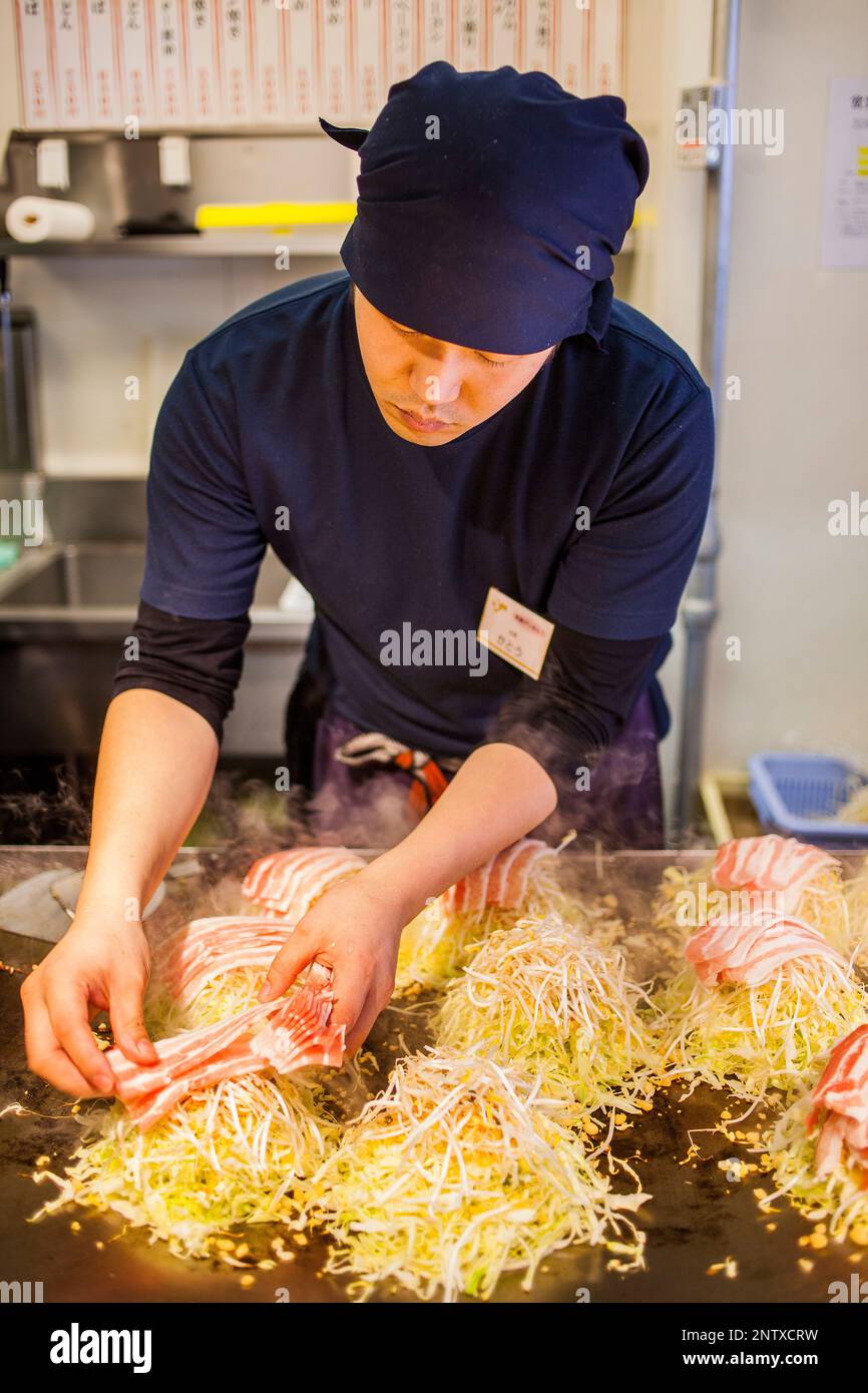 Chef Cooking Okonomiyaki, in a restaurant of Okonomi-mura, Hiroshima ...