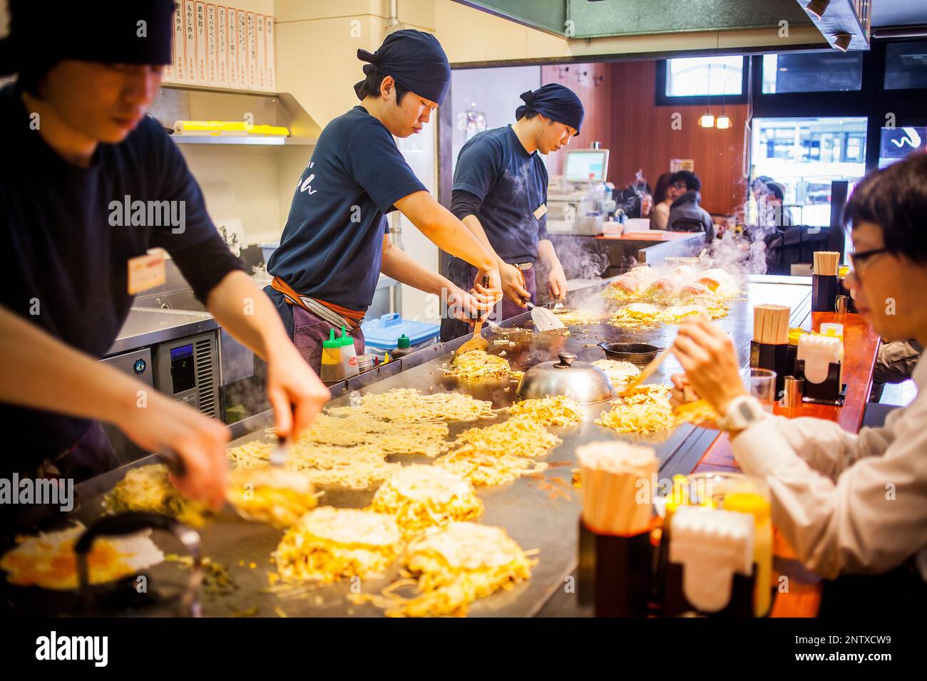 Chef Cooking Okonomiyaki, in a restaurant of Okonomi-mura, Hiroshima ...