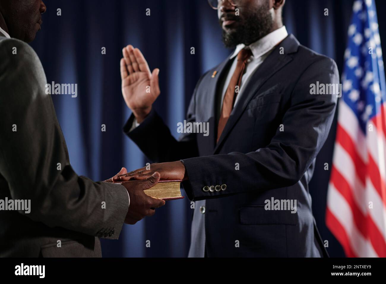 Close-up of young African American man in formalwear giving oath of ...