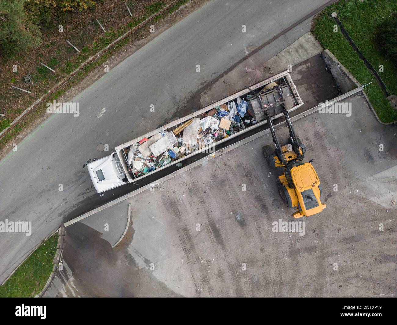 Skid steer loader loading a truck with waste material transferred for ...