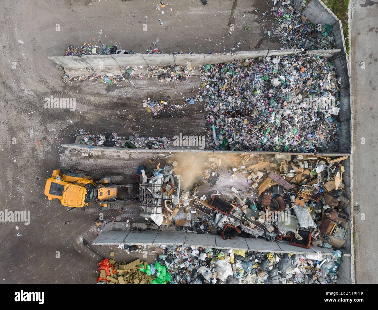 Landfill site, a pile of stinky different junk disposal in the concrete section for unsorted ...