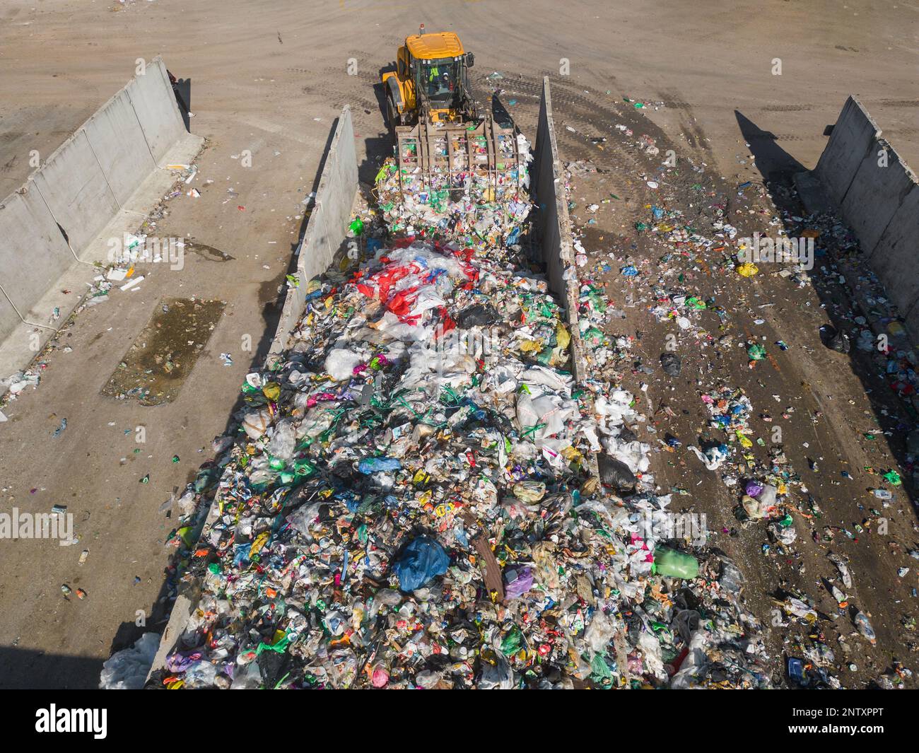 Skid steer loader moving plastic garbage with scrap grapple on the ...