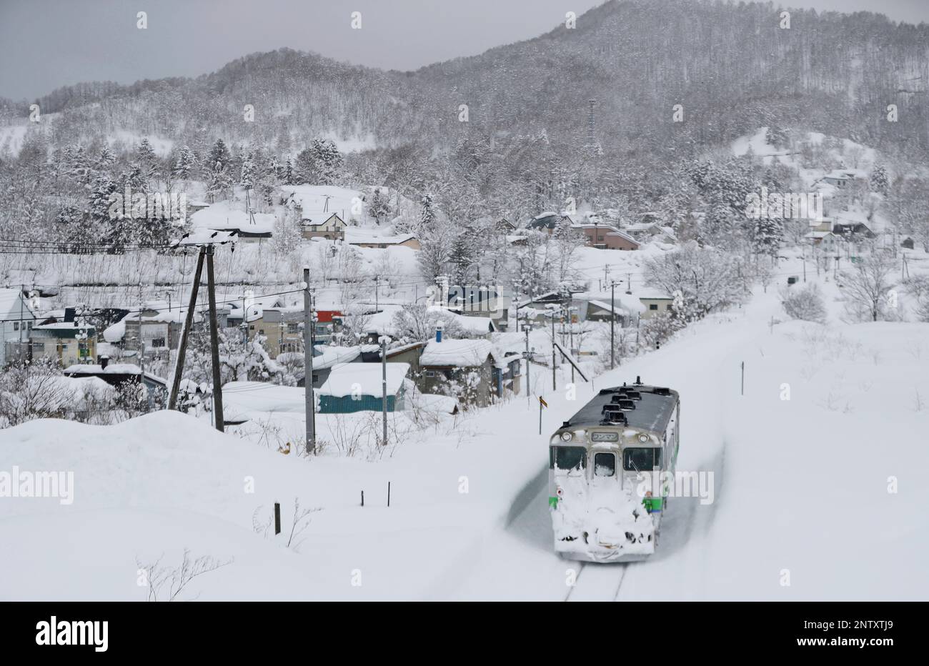 A train runs through snow covered landscape of Yubari City, Hokkaido on ...