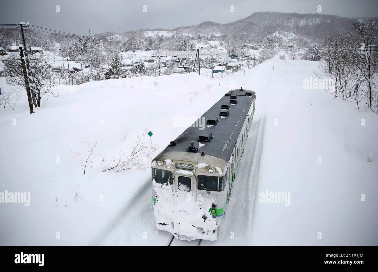 A train runs through snow covered landscape of Yubari City, Hokkaido on ...