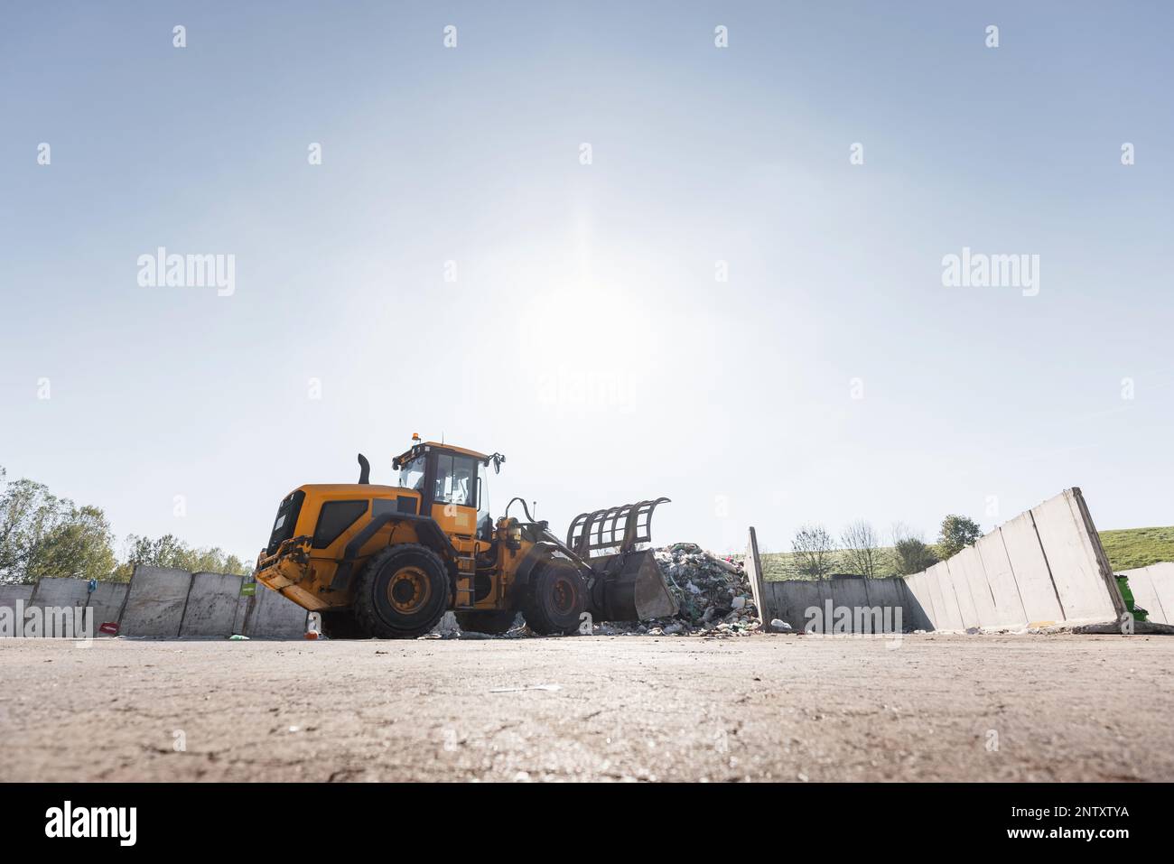 Front loader with scrap handling grapple bucket moving forward and ...