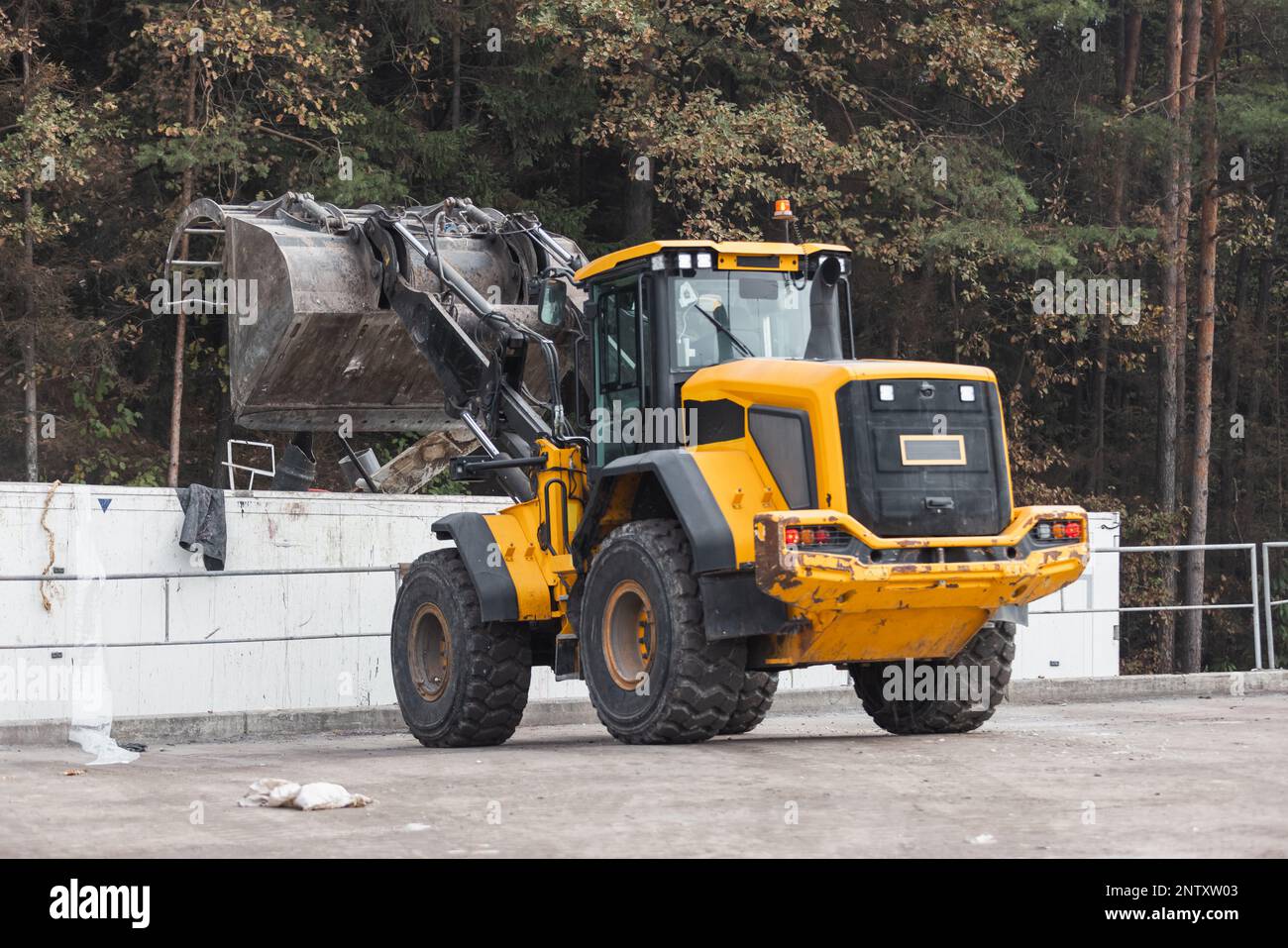 Skid steer loader loading a truck with waste material transferred for ...