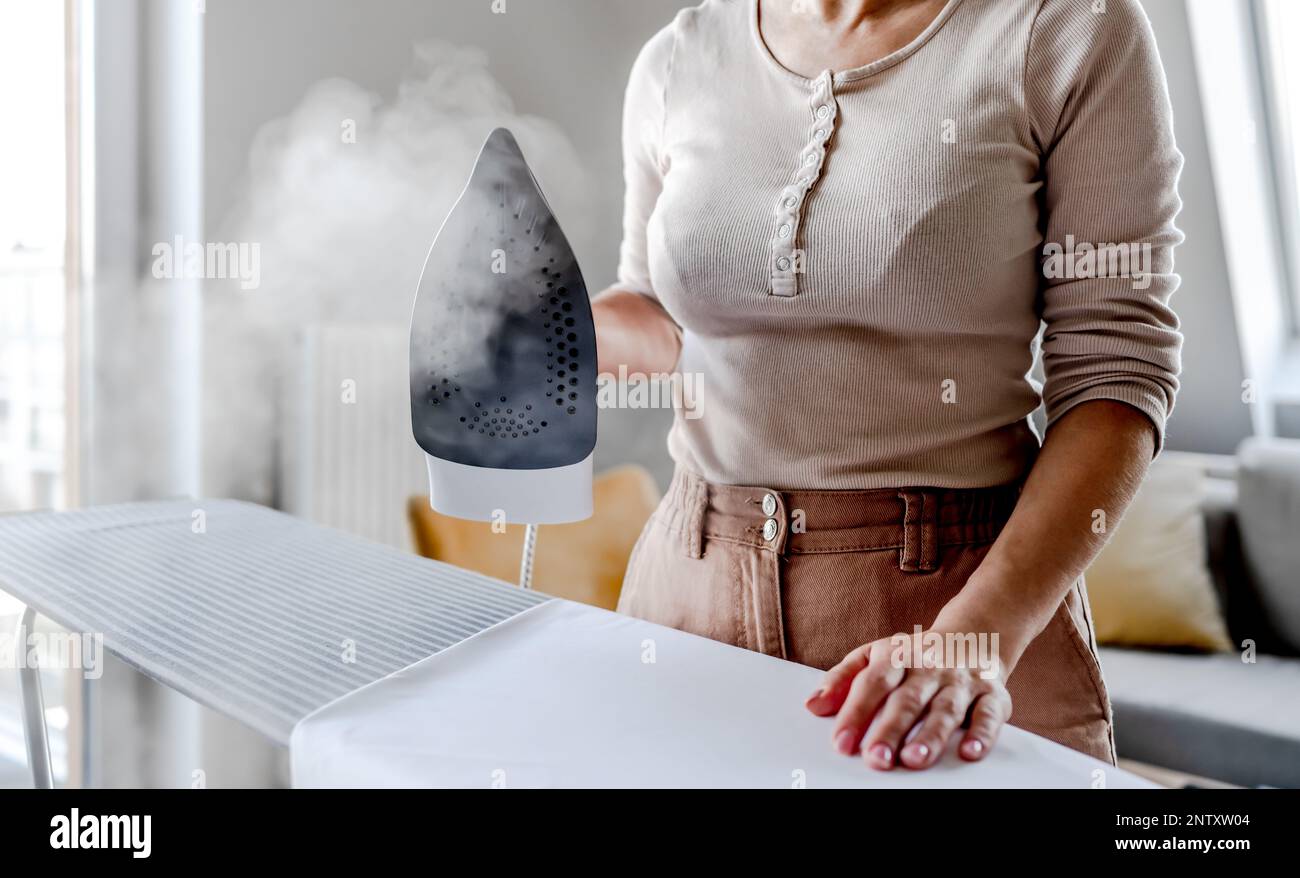 Female hand using steam iron hi-res stock photography and images - Alamy