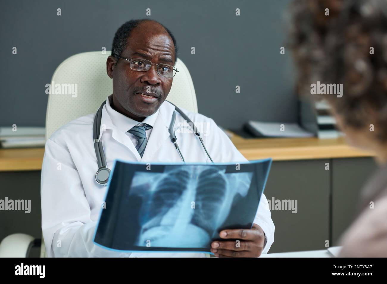 Confident experienced African American male radiologist with lung x-ray ...