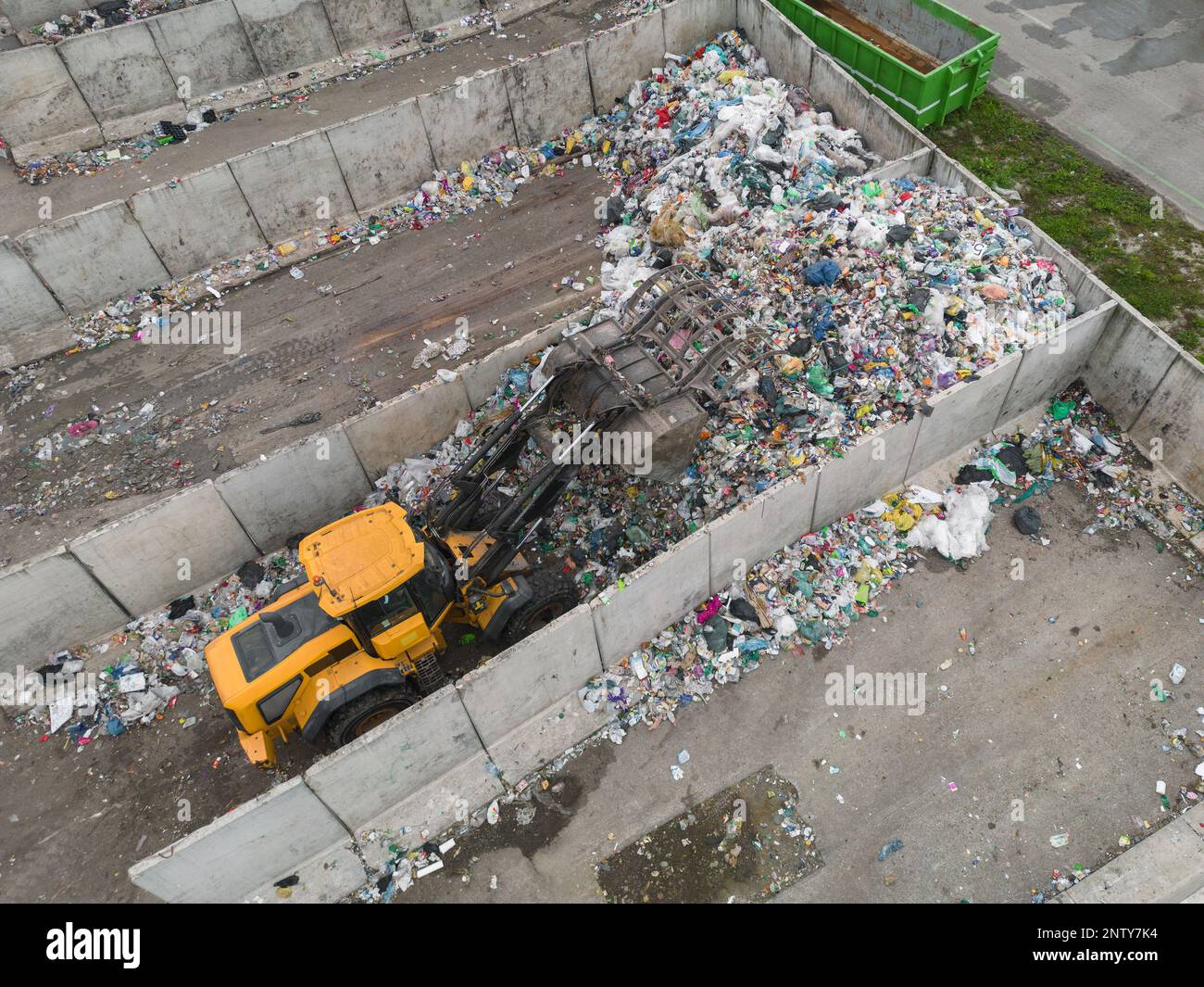 Wheel loader doing a job at waste management plant, using scrap grapple ...