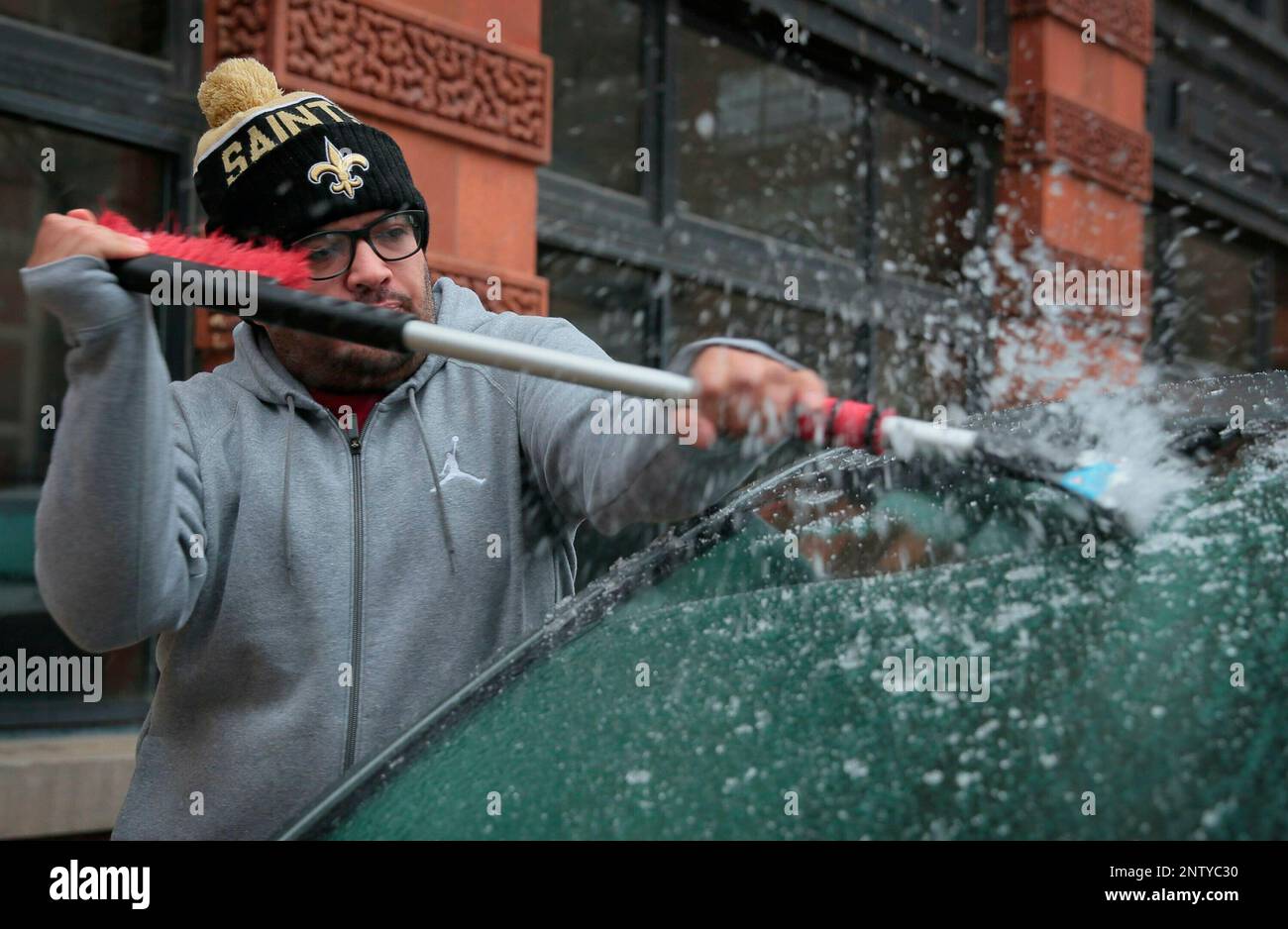 Rafael Rodriguez scrapes the ice off his car in downtown St. Louis on ...