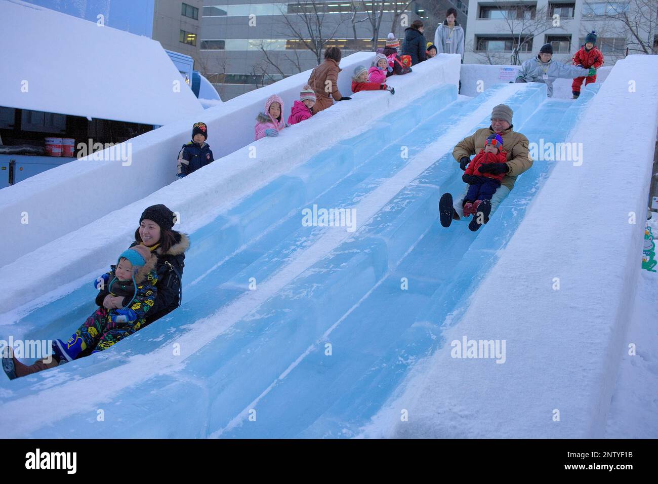 Visitors sliding down a slope,Sapporo snow festival,snow sculpture ...