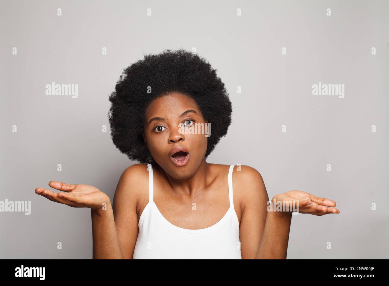 Confused young cute brunette woman shrugging shoulders, uncertain ...