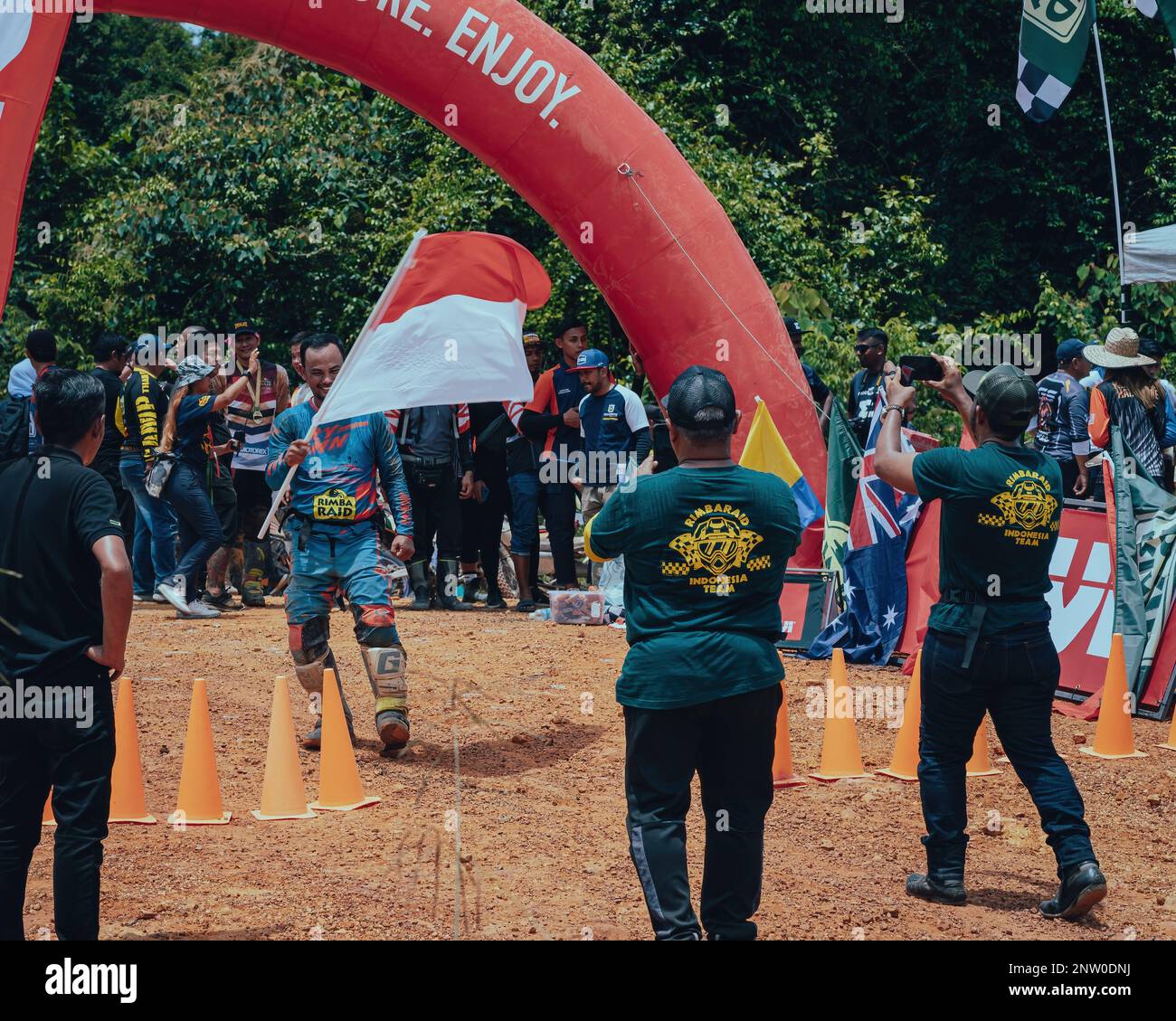 Motorcyclist from Indonesia waving the flag at the Rimba Raid event ...