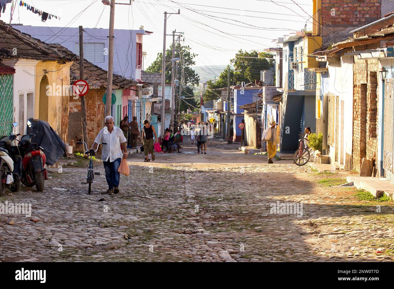 A light-filled alley in Trinidad, Cuba, with old, colourful buildings ...