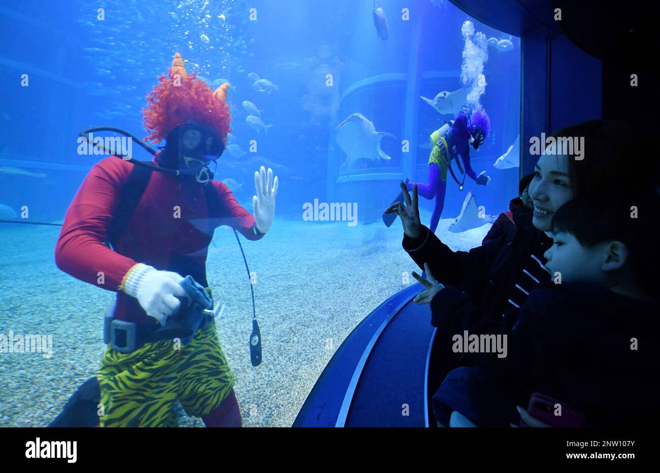Divers wearing devil costume welocome visitors in a giant fish tank at ...