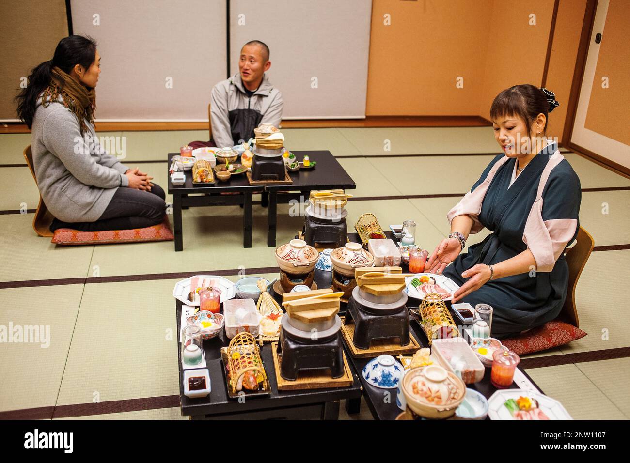 Waitress serving traditional food, restaurant of Fujiya Ryokan ...
