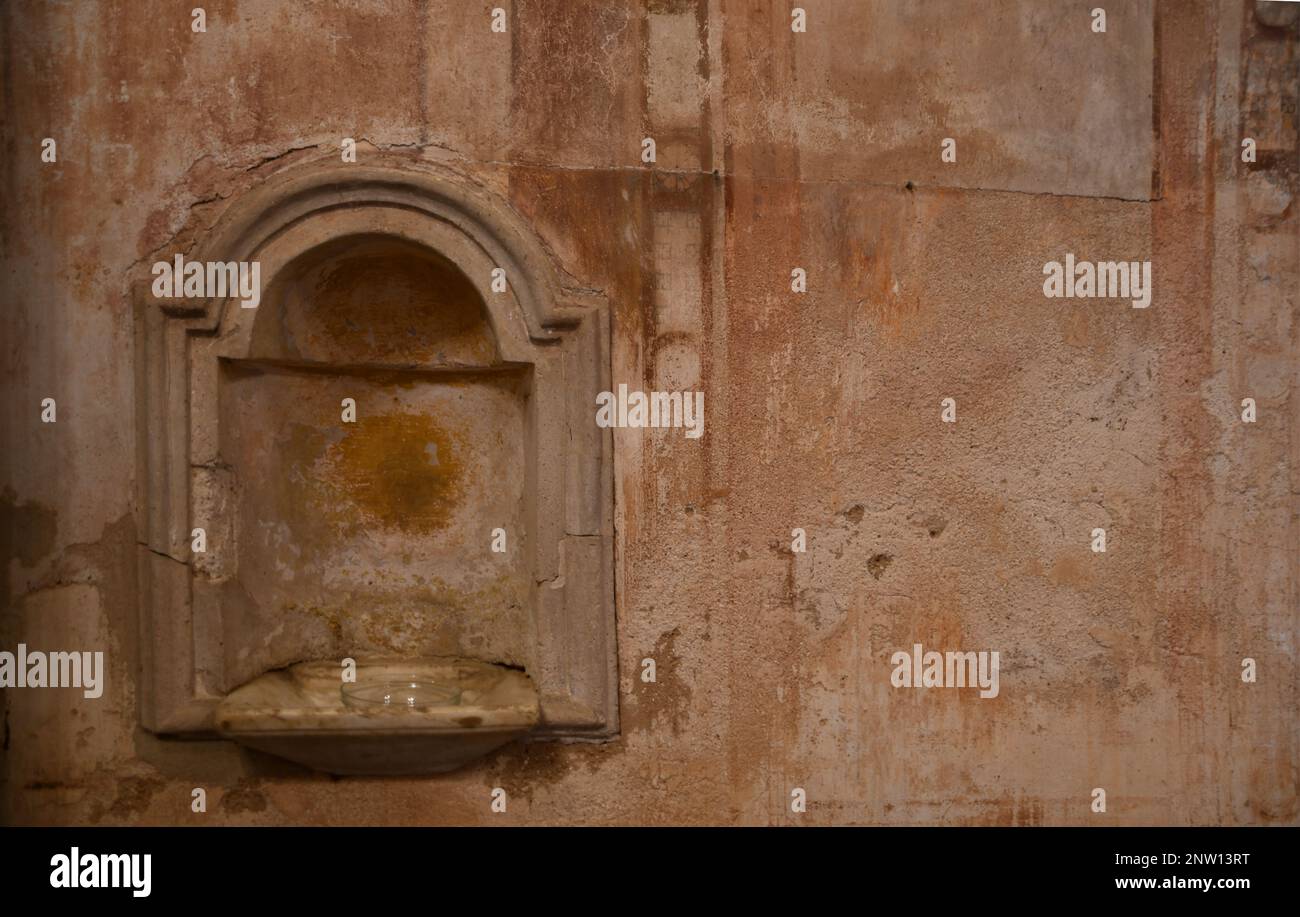 The ancient marble baptismal font on the wall of a catholic church ...