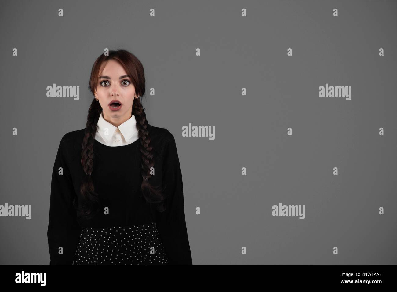 Shocked teen girl student in gothic black clothes with pigtails, open mouth look at camera Stock ...