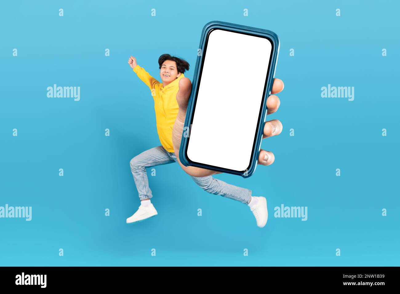 Korean Boy Showing Big Phone Screen Jumping Over Blue Background Stock ...