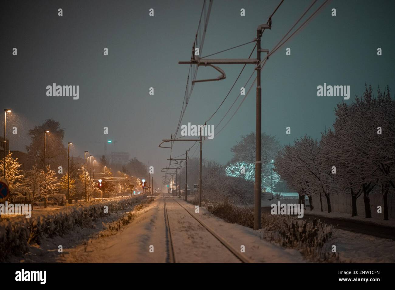 Snow capped railway track or railroad covered with snow during night ...