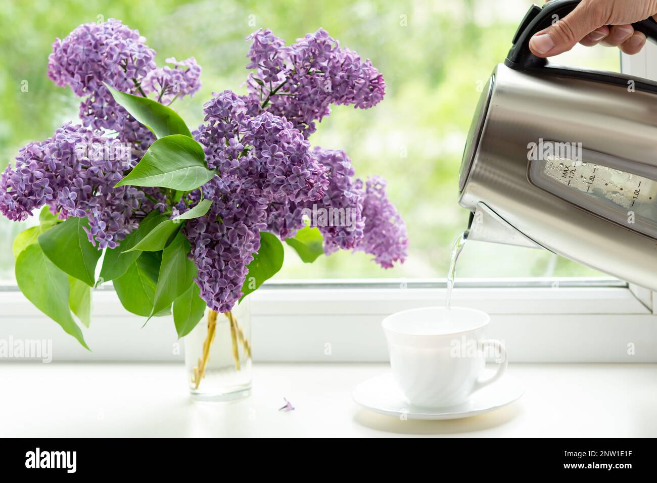 Home interior with a bouquet of blooming lilac flowers on the window ...