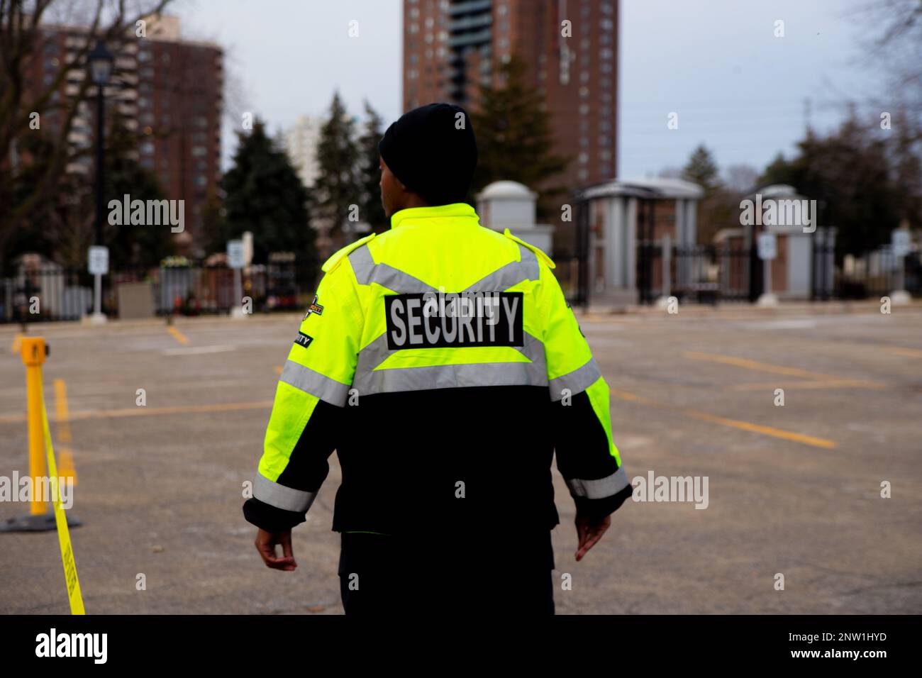 Security guard setting up a caution tape to do parking enforcement at ...