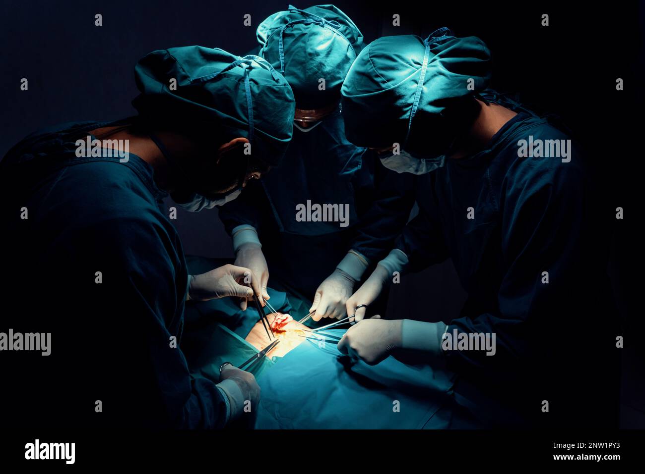 Surgical team performing surgery to patient in sterile operating room ...