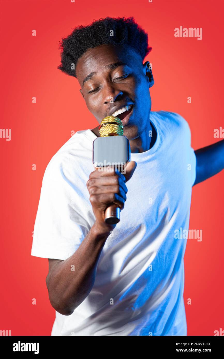 Cool young black guy with microphone in his hand singing Stock Photo ...