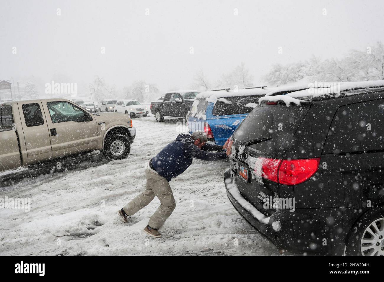 Matthew Barney gives a push to get his family's vehicle out of a ...