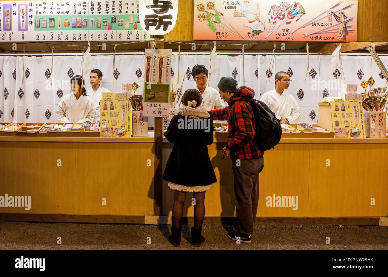 Couple buying amulets and omikuji paper oracle, during Hatsumode, is ...