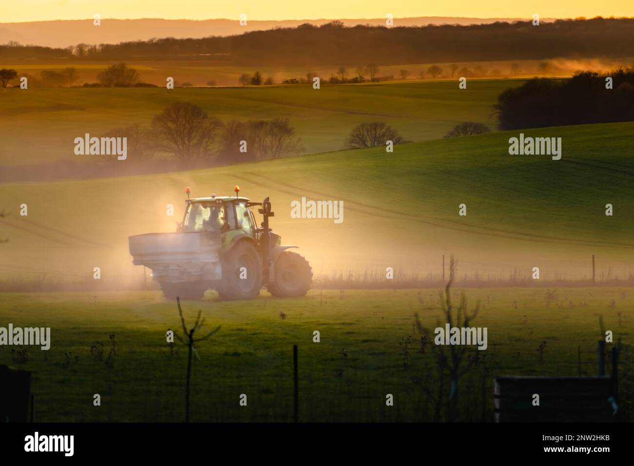 Tractor in farmland working on soil field with sunset, big equipment ...