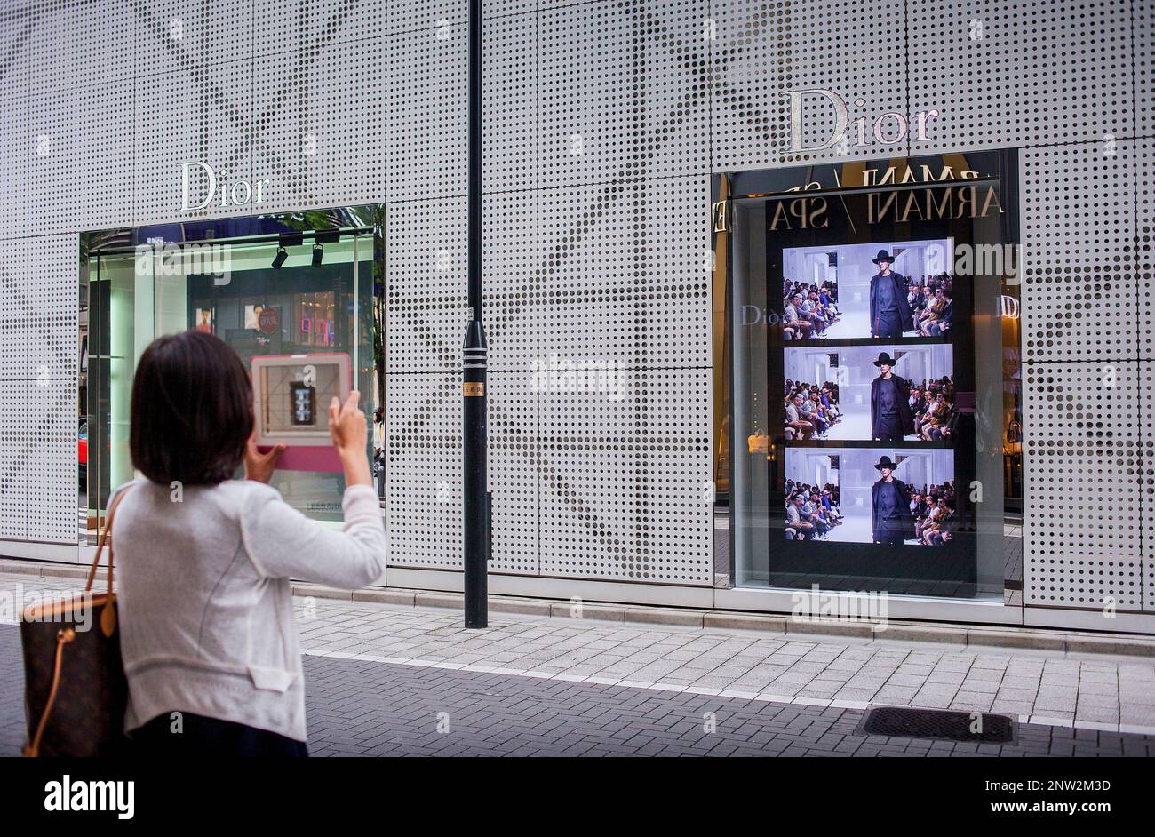 woman taking pictures of the Dior shop, in Ginza. Harumi St.Tokyo city ...