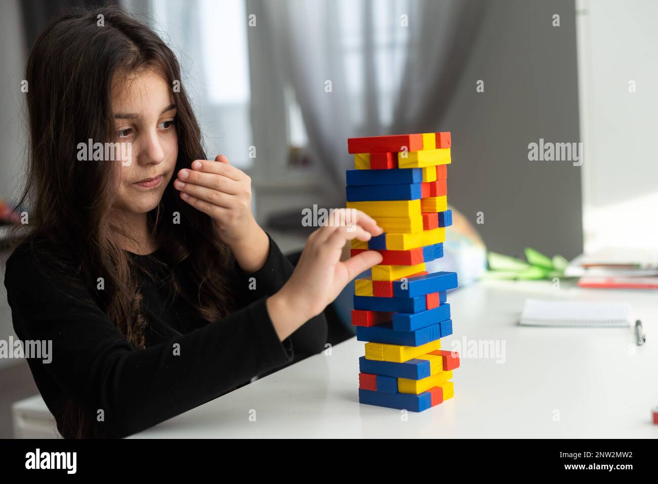 Cute little girl excites with wooden block game Stock Photo - Alamy