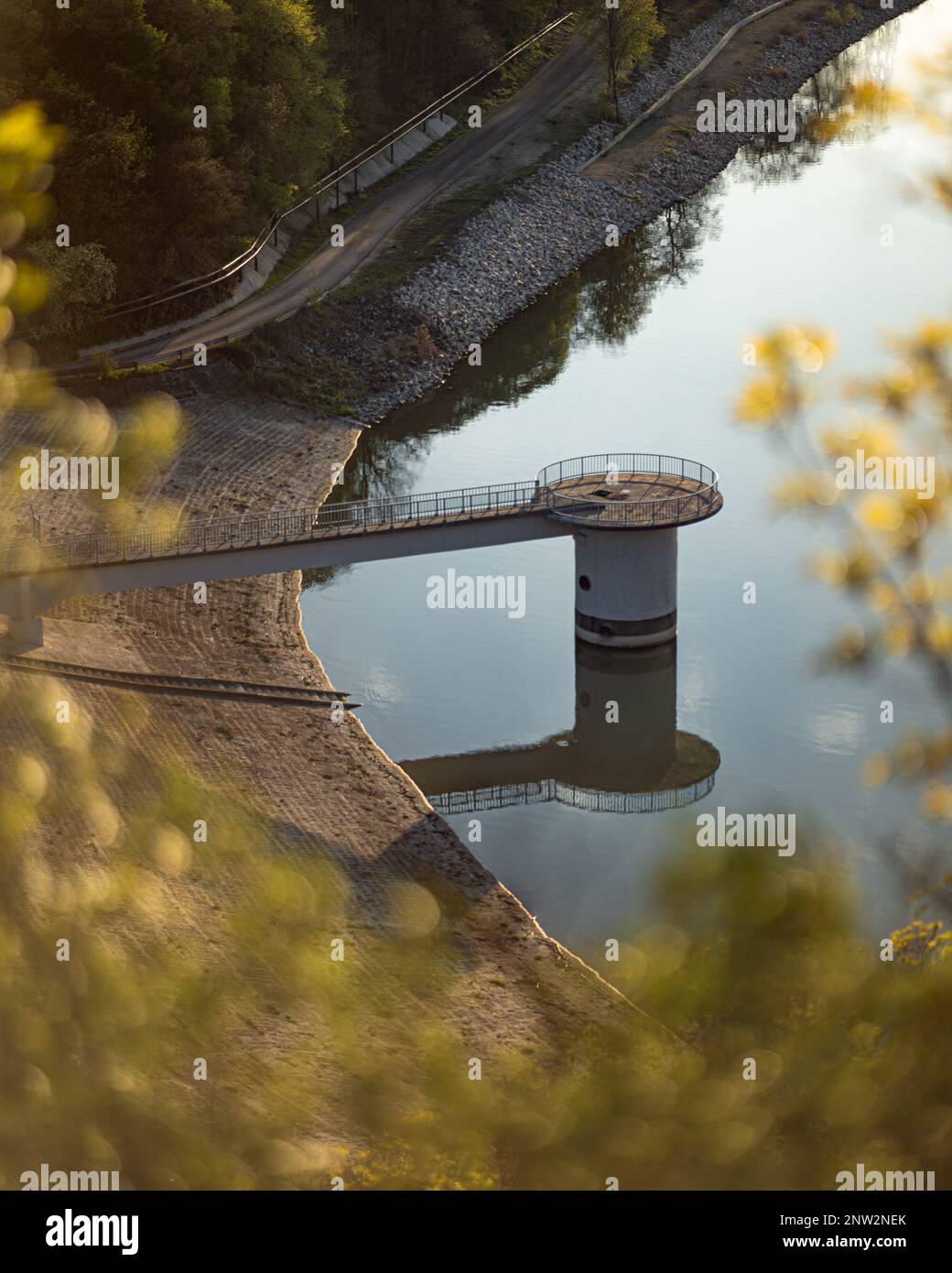This striking image depicts a small bridge crossing a river and leading ...