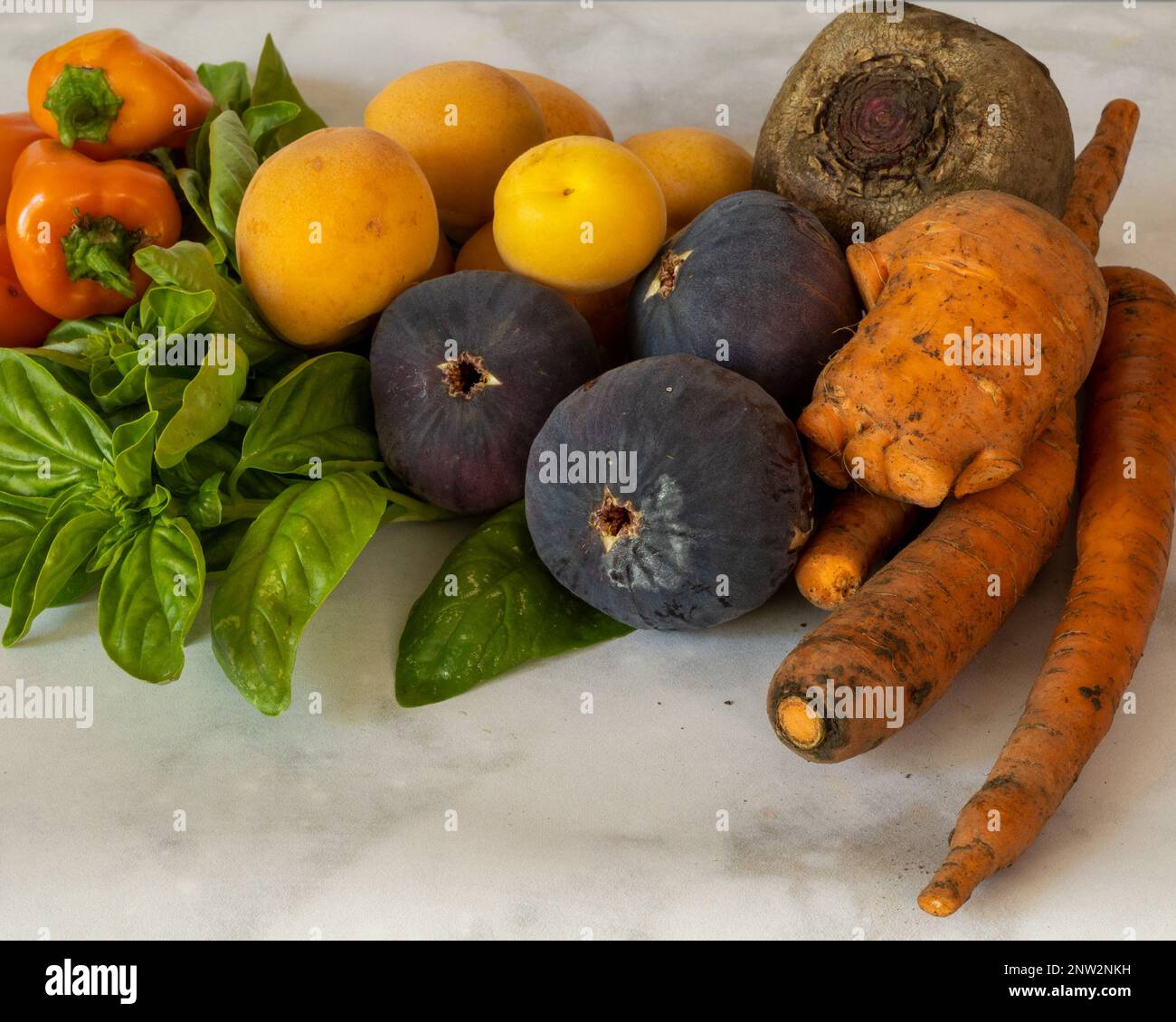 Close-up on organic vegetables and fruit, against white marble ...