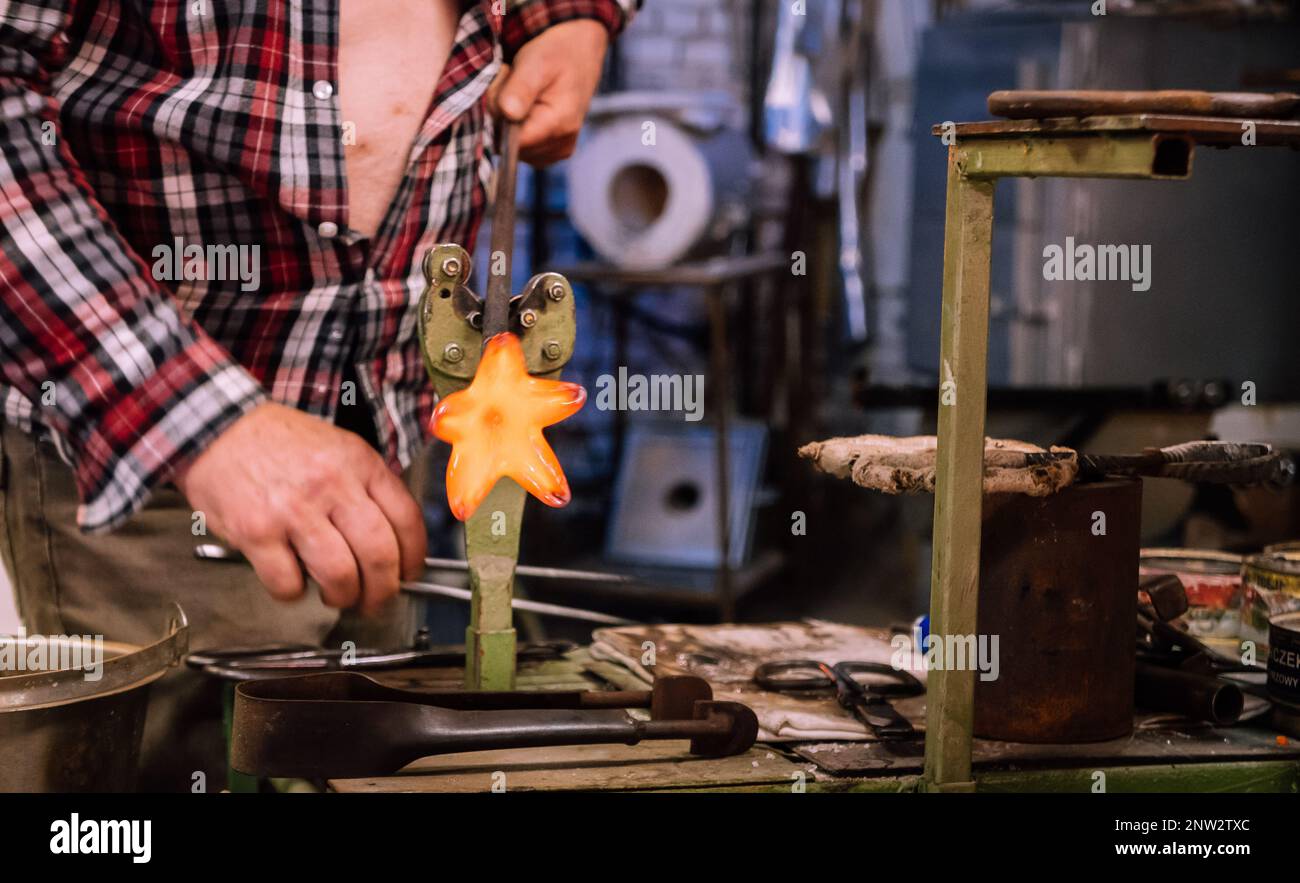 A glassworks worker shows traditional methods of making decorative ...