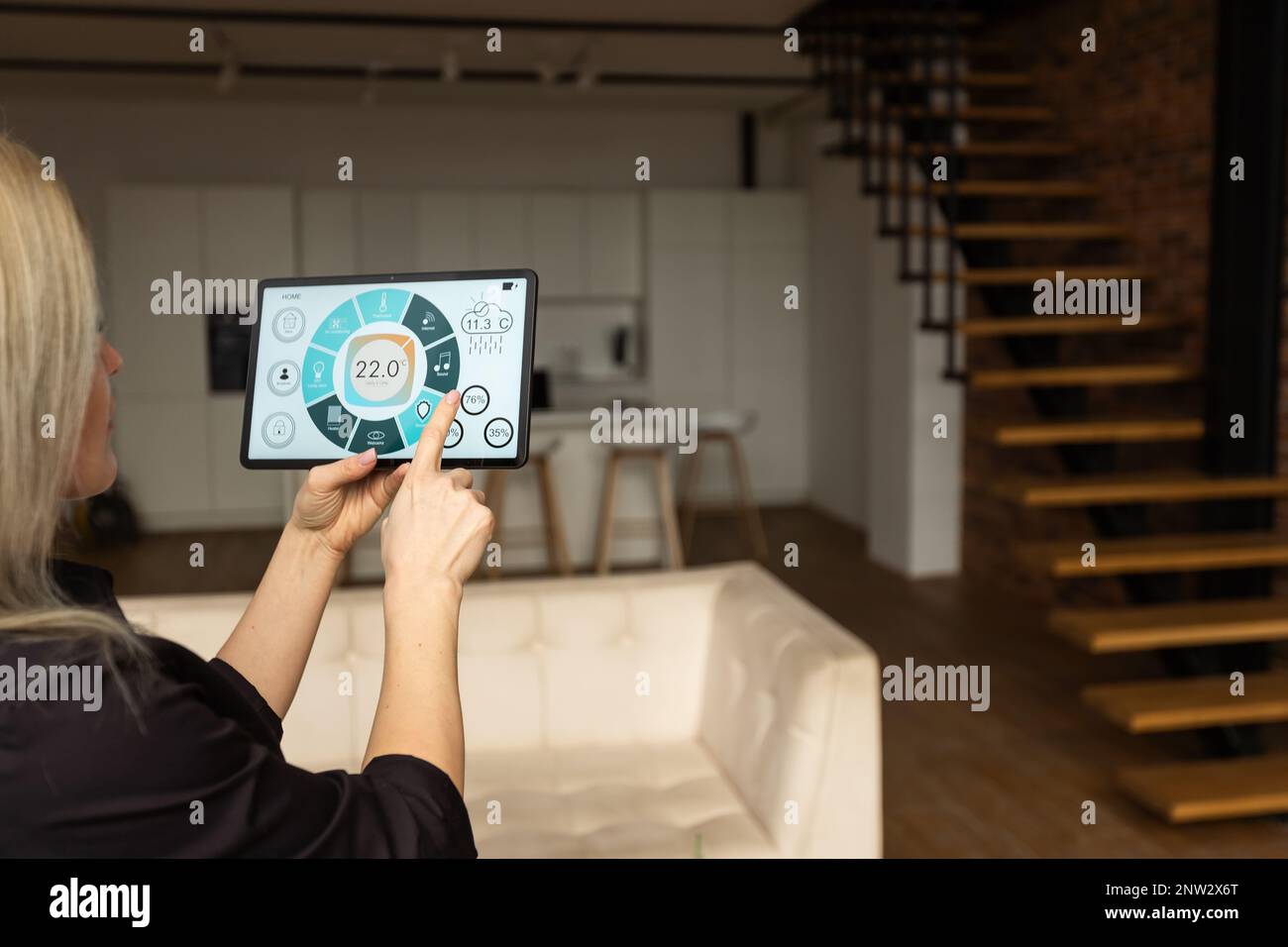 Smart home control on tablet. Interior of living room in the background ...